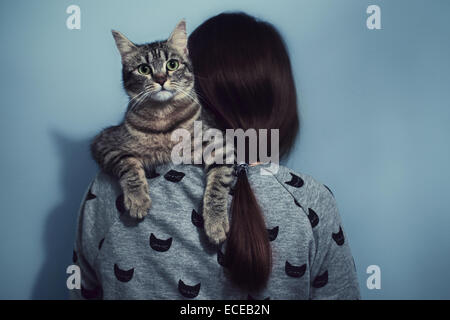 Young woman carrying cat on shoulder Stock Photo - Alamy