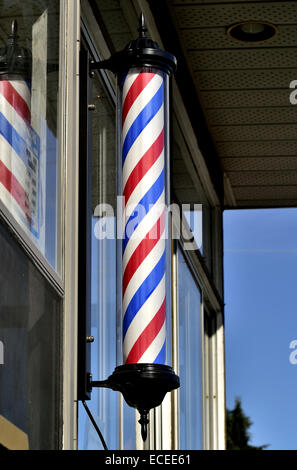 Red and white pole advertising a barber s shop Stock Photo - Alamy