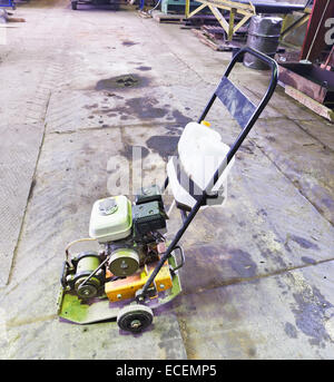 Gasoline Vibrating rammer with a vibrating plate on a construction site ...