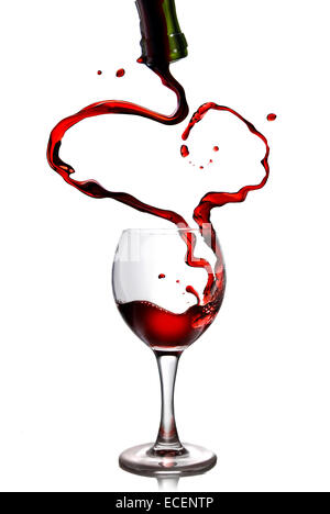 pouring wine from a bottle into a goblet on a black background with a ...
