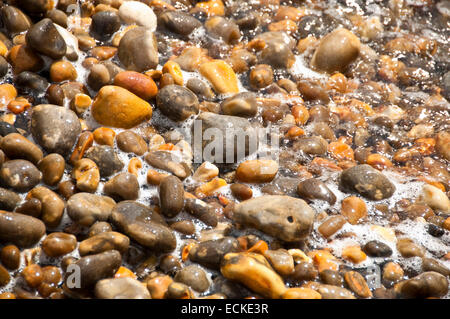 Pebbly shoreline and clear sea and rocky isle or pinnacle called Gebla ...