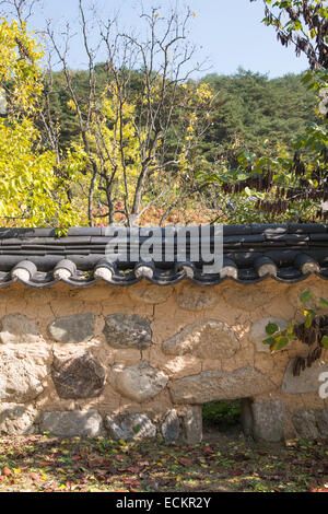 Korean traditional house with tiled roof, curved eaves, and white walls ...