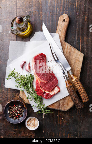 Cutting board, seasonings and oil set on dark background, top view ...