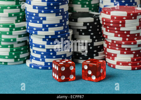 Red dice and casino gaming chips on dark mirrored table. Background for ...