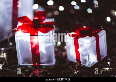 Gifts under glowing Christmas tree near blue wall Stock Photo - Alamy