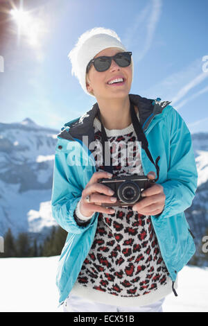 A young woman photographing the snowy mountain in the highland Stock ...