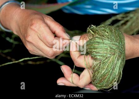 A Hmong woman hand spins hemp prior to dying it black and weaving ...