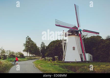 Man standing by a windmill Stock Photo - Alamy