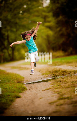 child girl jumping over puddle Stock Photo - Alamy