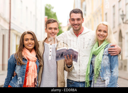 group of friends with city guide exploring town Stock Photo - Alamy