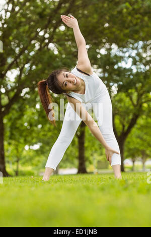 A portrait of a asian woman doing stretching exercise during outdoor cross training workout ...