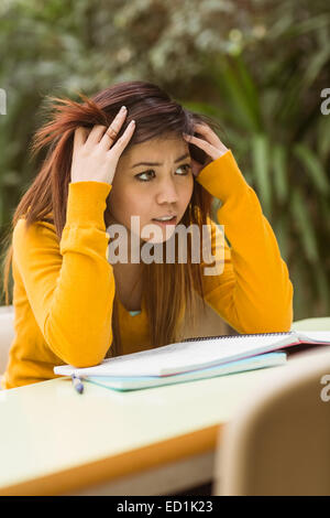 Female student with books in hands on a blue background and yellow ...