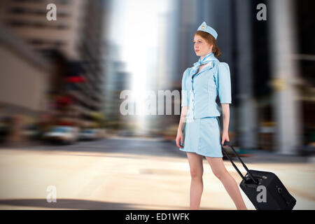 Young air hostess pulling luggage bag while on call in the airport ...