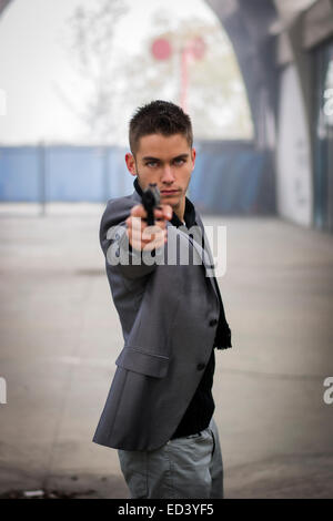 Well dressed handsome young detective or policeman or mobster holding a ...