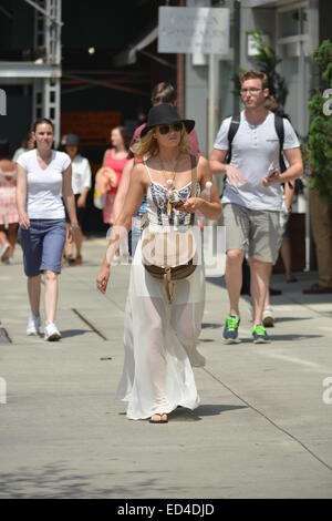 Beth Behrs walking in Soho in a long white dress complimented with a ...