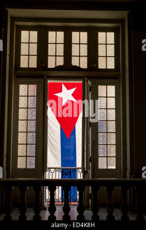 Cuban flag with door and window facade at colonial Cuban house in ...
