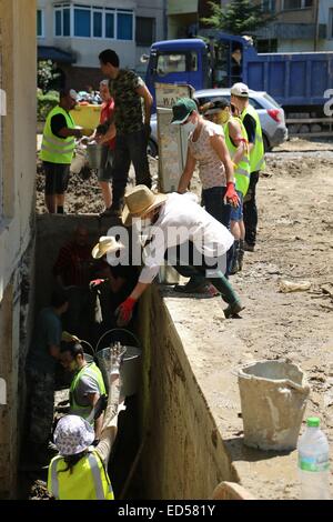 People and rescue workers try to salvage what they can from the ...