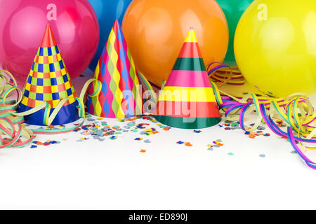 Party hats and confetti on red background Stock Photo - Alamy