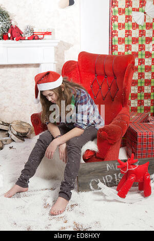 Red-haired girl in Santa Claus hat with cat in Christmas hat. Amazing ...
