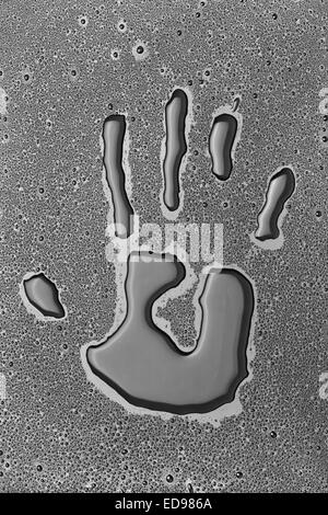 Handprint man out of the water on a black background Stock Photo - Alamy