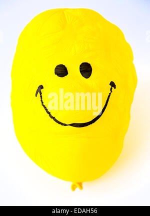 old Balloon, yellow, shriveled with friendly smiley face, sunken ...
