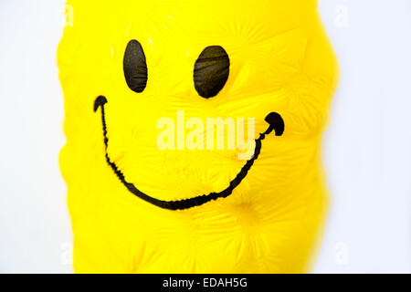 old Balloon, yellow, shriveled with friendly smiley face, sunken ...