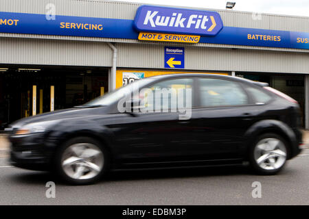 A car passes a Kwik Fit garage Stock Photo - Alamy