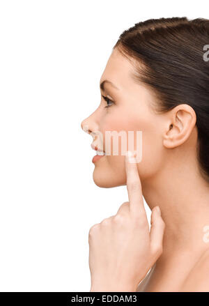 calm young woman pointing at her cheek Stock Photo - Alamy