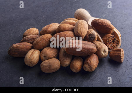 A bunch of nutmeg on black stone background Stock Photo - Alamy