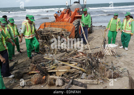 Janitor cleaning up trash in Kuta Beach, Bali Indonesia. Kuta is one of ...