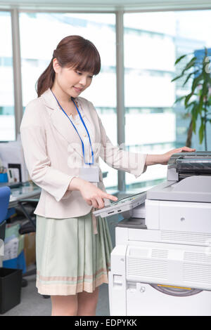 Businesswoman Using Copier Machine Stock Photo - Alamy