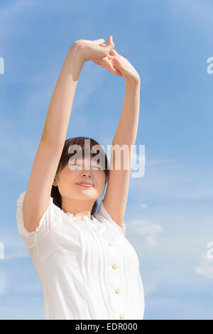 young Asian woman stretching arms after waking up feeling refreshed ...