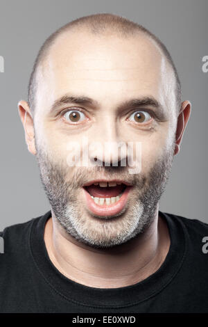 Mature handsome man with beard amazed and surprised looking up ...