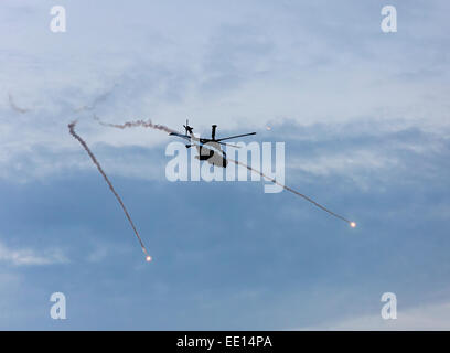 Military helicopter in flight firing off flare decoys at night Stock ...