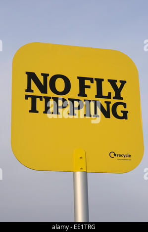 A yellow "No Dumping Rubbish" sign fixed to a lamp post, warning of a £ ...