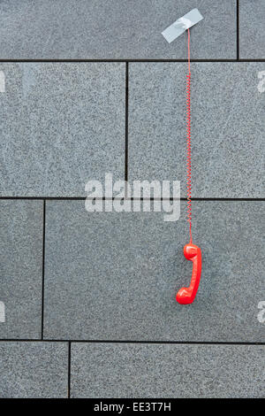Red telephone receiver hanging down Stock Photo - Alamy