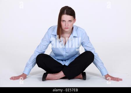 Stern businesswoman sitting cross legged Stock Photo - Alamy