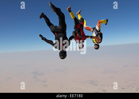 This freefly skydiving team is holding hand together in a head-down ...