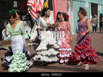 Spanish women with colorful flamenco dresses in front of marquees ...