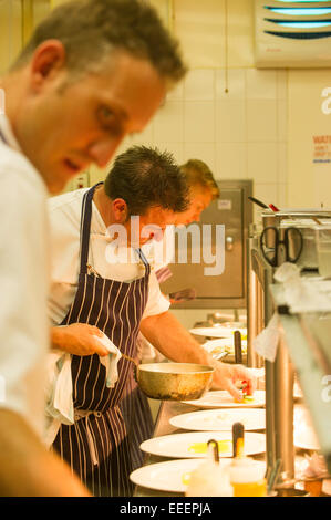 Staff of restaurant with head chef working together in kitchen Stock ...