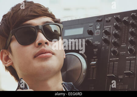 Handsome asian guy with turntables dj mixer Stock Photo - Alamy