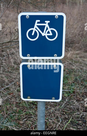 A blue and white sign with a bicycle image against a cloudy sky ...