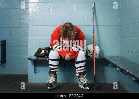 Portrait of tired hockey player in protective uniform in a shadow on ...