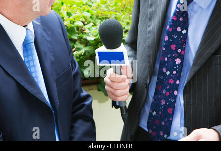 Man being interviewed by television news crew while treading the Stock ...