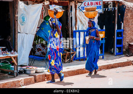Fulani women carrying pumpkins on head and walking on the streets, Mali ...