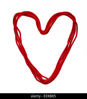 A red cord in a heart shape amongst tangled black cables and cords ...