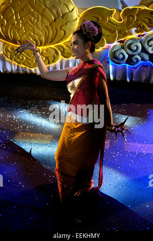 A young woman of Asian origin taking a photo of a street entertainer on ...