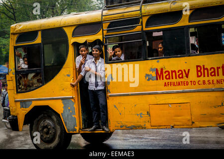Students cheering out of the entrance door of a school bus moving on a ...
