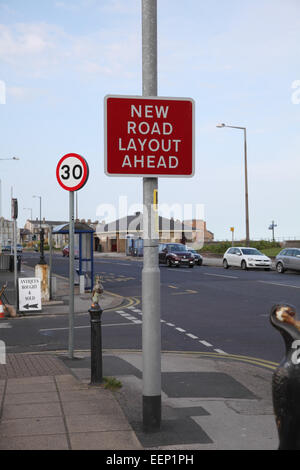 A "New Road Layout Ahead" sign on a main road near a busy junction on ...