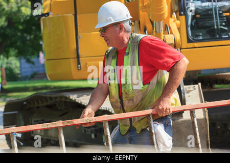 Worker Carrying Ladder At Construction Site Stock Photo - Alamy